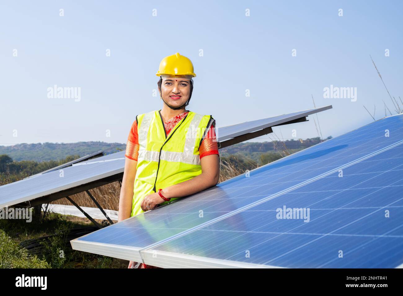 Portrait of Young indian woman technician wearing yellow hard hat ...