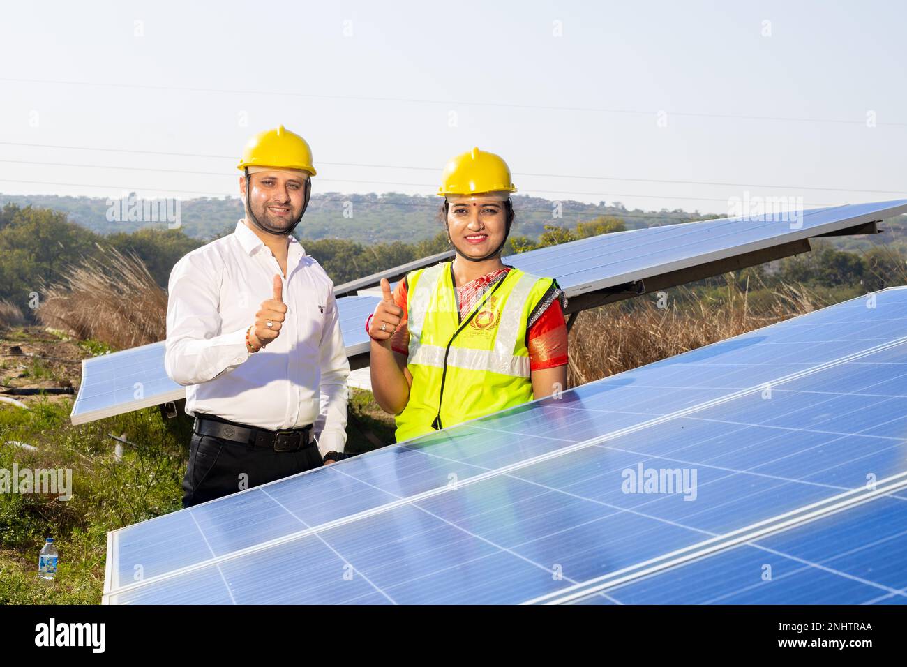 Portrait of Young indian woman technicians standing near solar panels.Industrial workers solar ...