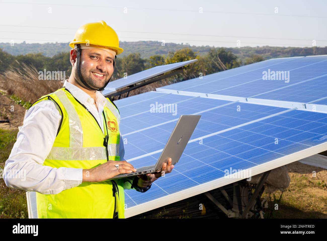 Portrait of Young indian man technician wearing yellow hard hat holding ...