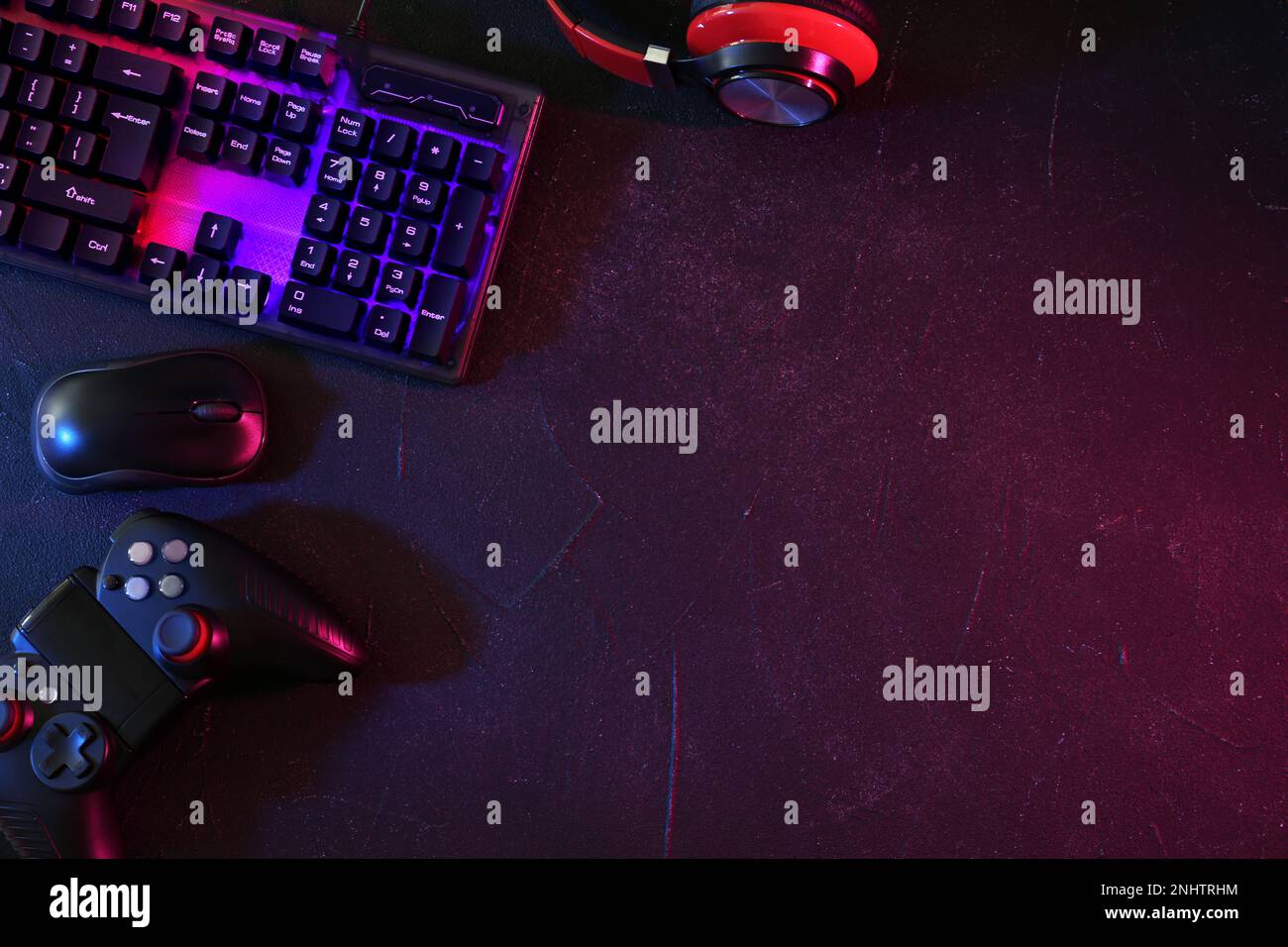 Modern RGB keyboard, mouse and video game controller on grey table ...