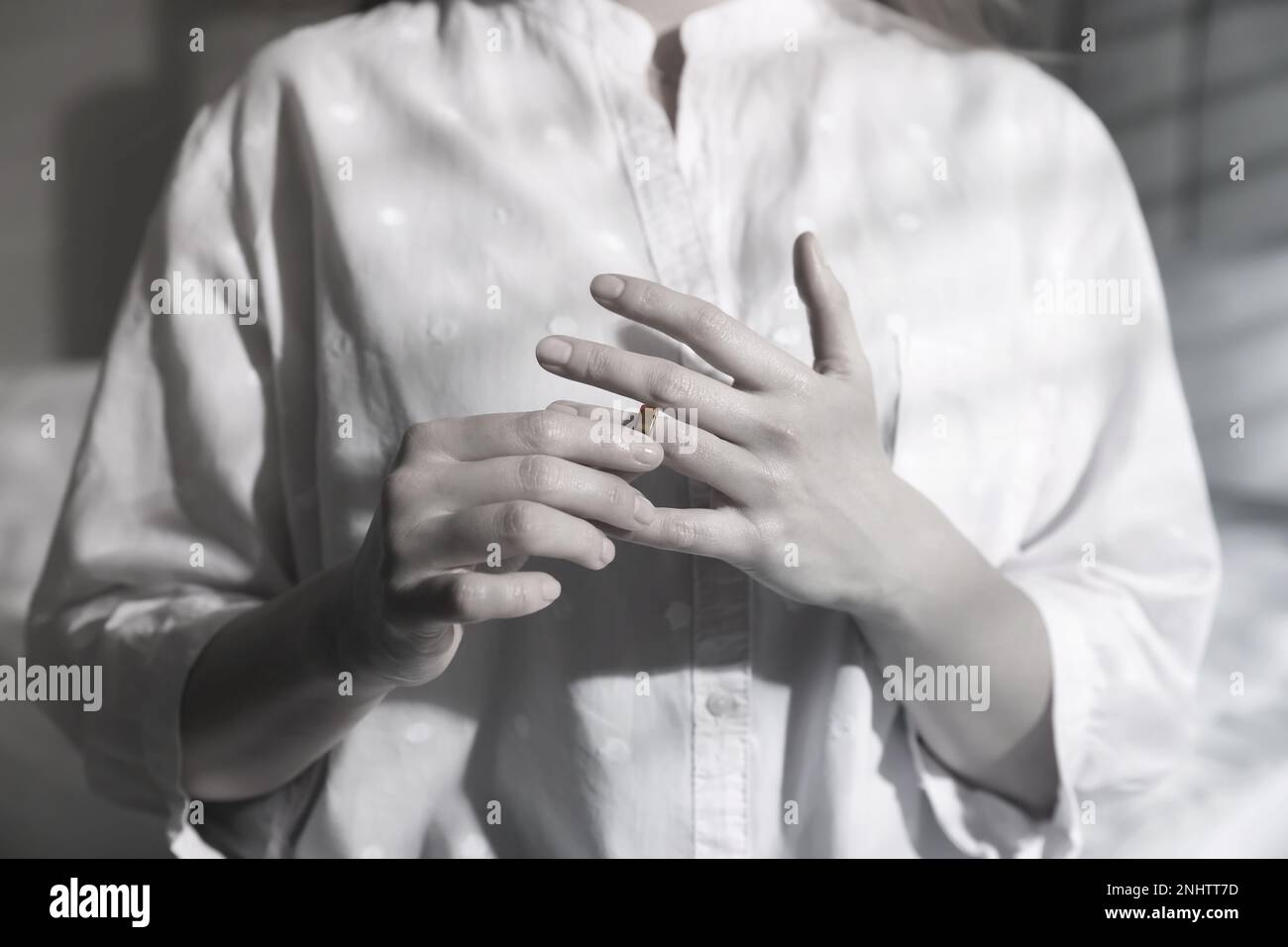 Woman taking off wedding ring indoors, closeup. Cheating and breakup ...
