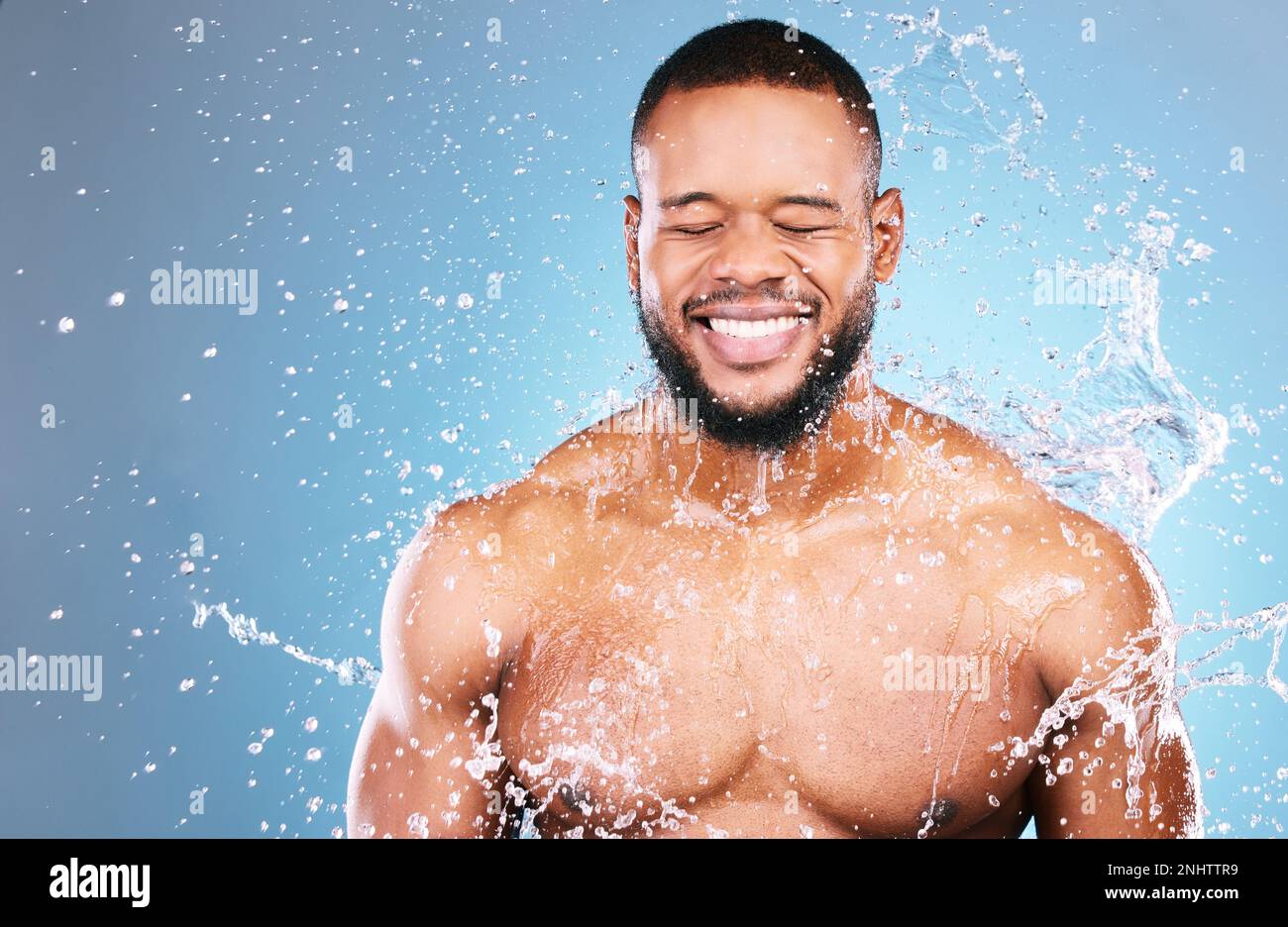 Shower, beauty and water splash for man cleaning, hygiene and skincare isolated in studio blue ...