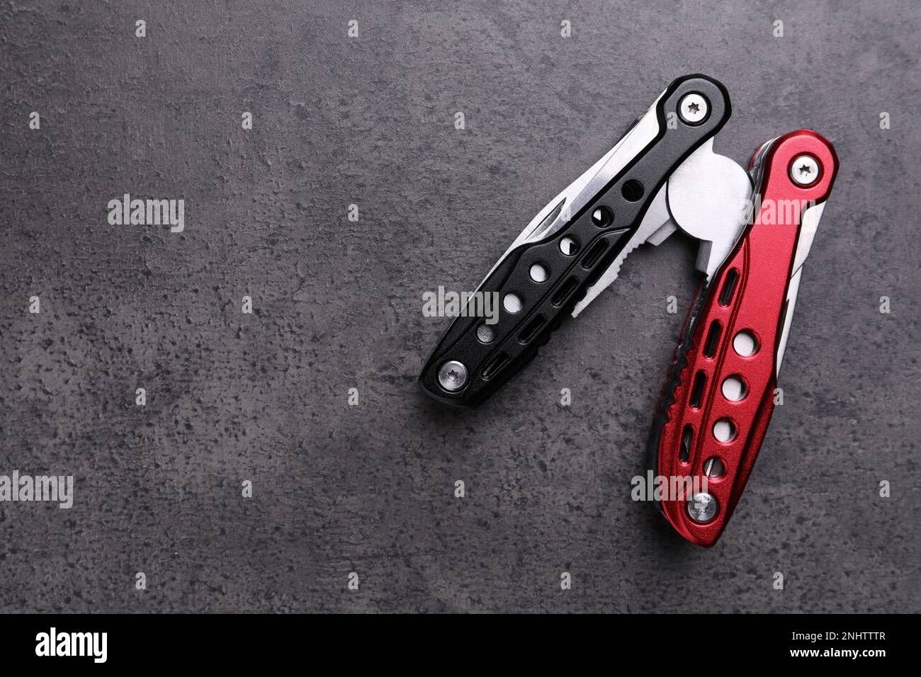 Modern compact portable multitool on grey table, top view. Space for ...