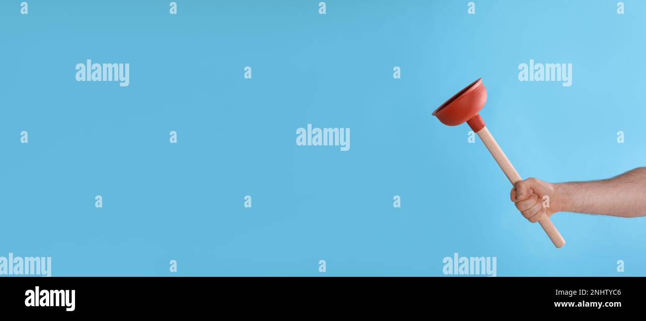 Man holding plunger on turquoise background, closeup. Space for text ...