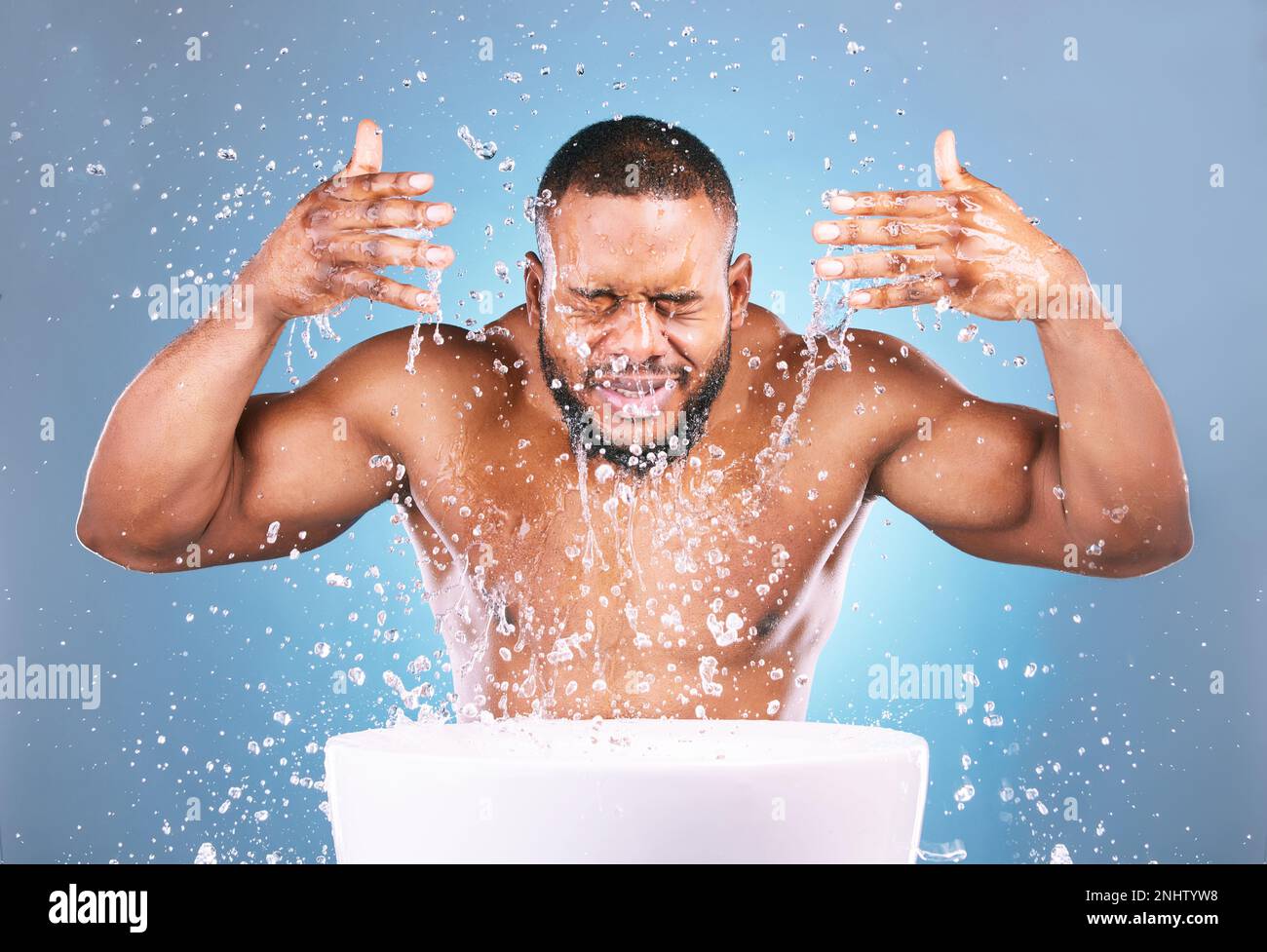 Water splash, hands or black man cleaning face for beauty, skincare or fresh hygiene on blue ...