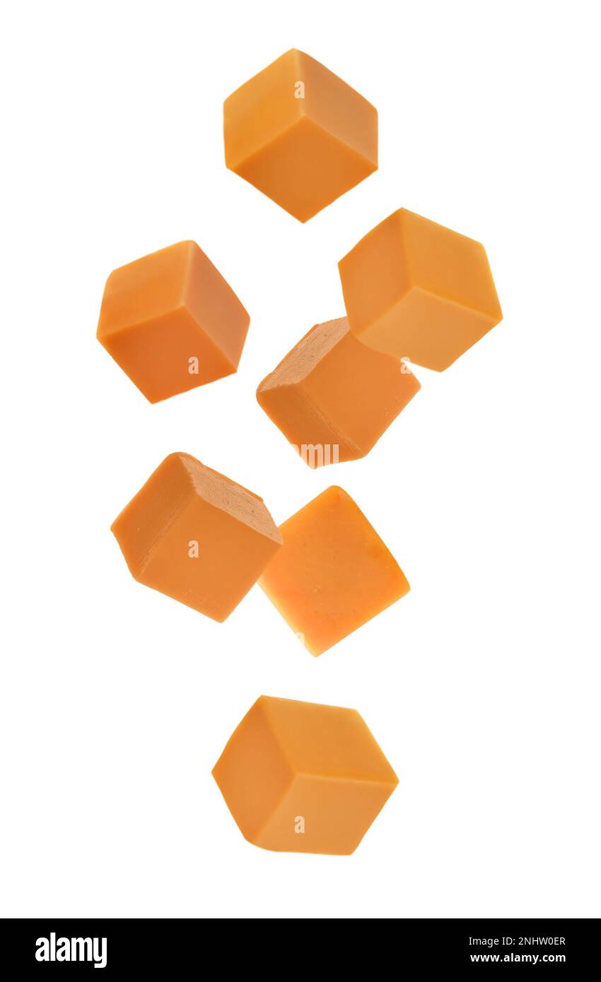 Delicious caramel cubes flying on white background Stock Photo - Alamy