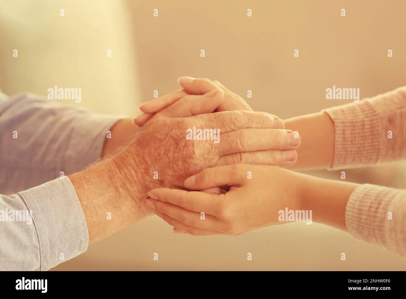Helping hands on blurred background, closeup. Elderly care concept ...