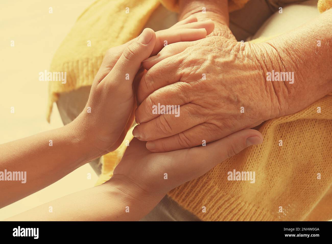 Helping hands on blurred background, closeup. Elderly care concept ...