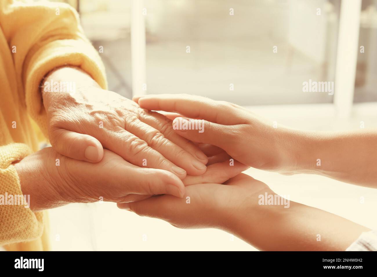 Helping hands on blurred background, closeup. Elderly care concept ...