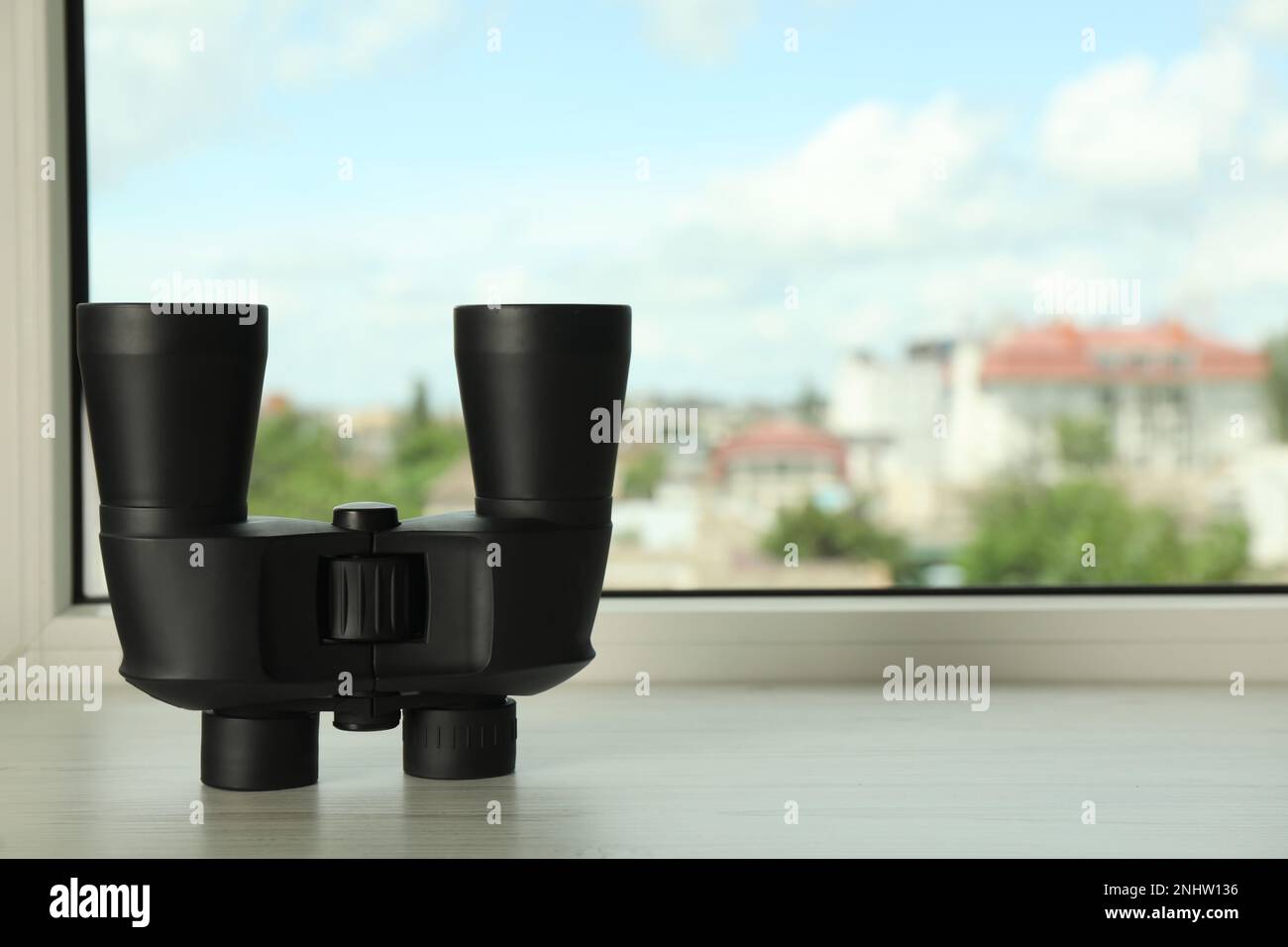 Black binoculars on white wooden window sill. Space for text Stock ...