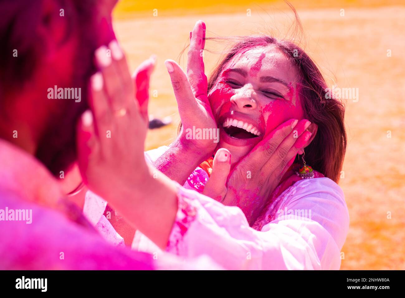 Happy young Indian couple having fun playing with colorful powder color ...