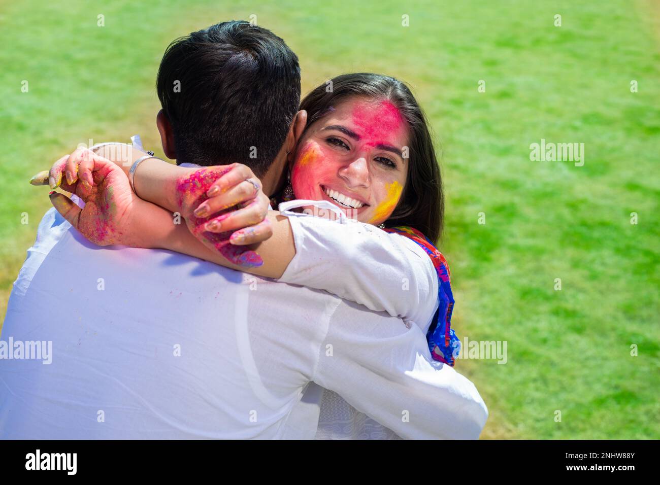 Happy young indina woman hug her husband while celebrating holi with ...