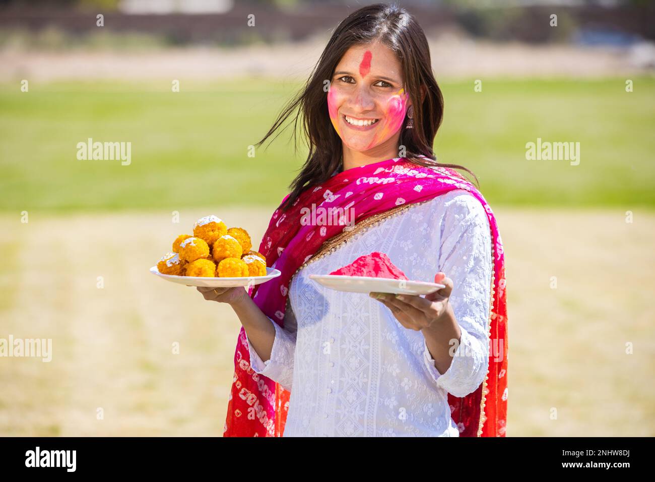 Happy indian woman holding plats full of laddu and powder color or ...