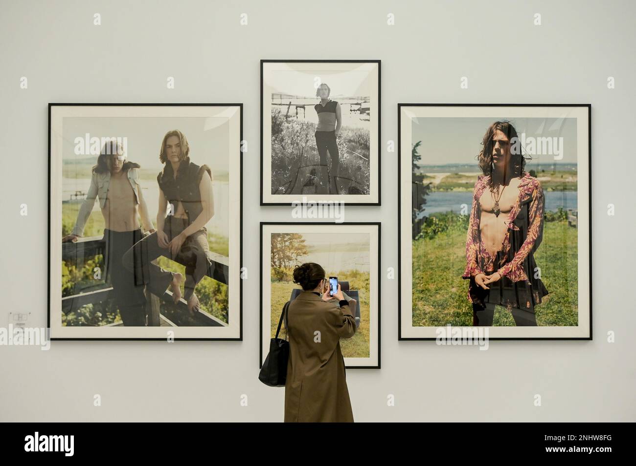A woman takes a picture of the photographs in the exhibition 'Steven ...