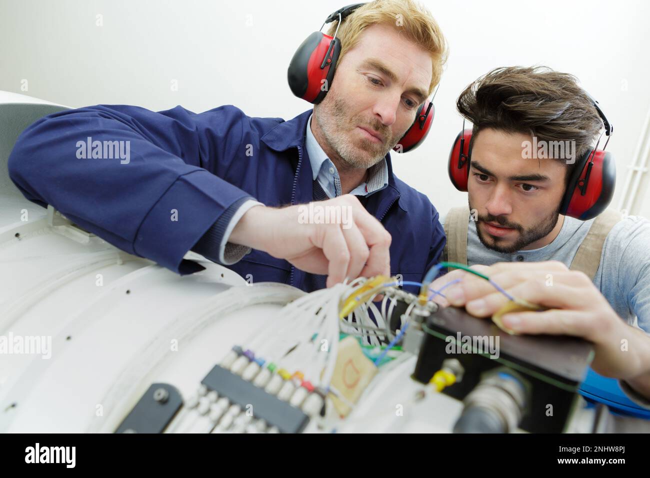 portrait of people working on airplane electronics Stock Photo - Alamy