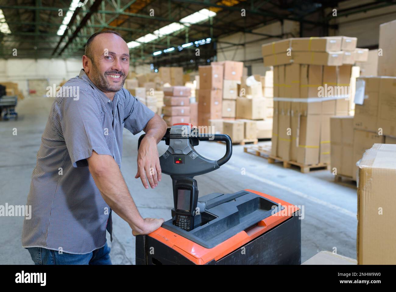 happy porter with boxes in a warehouse Stock Photo - Alamy