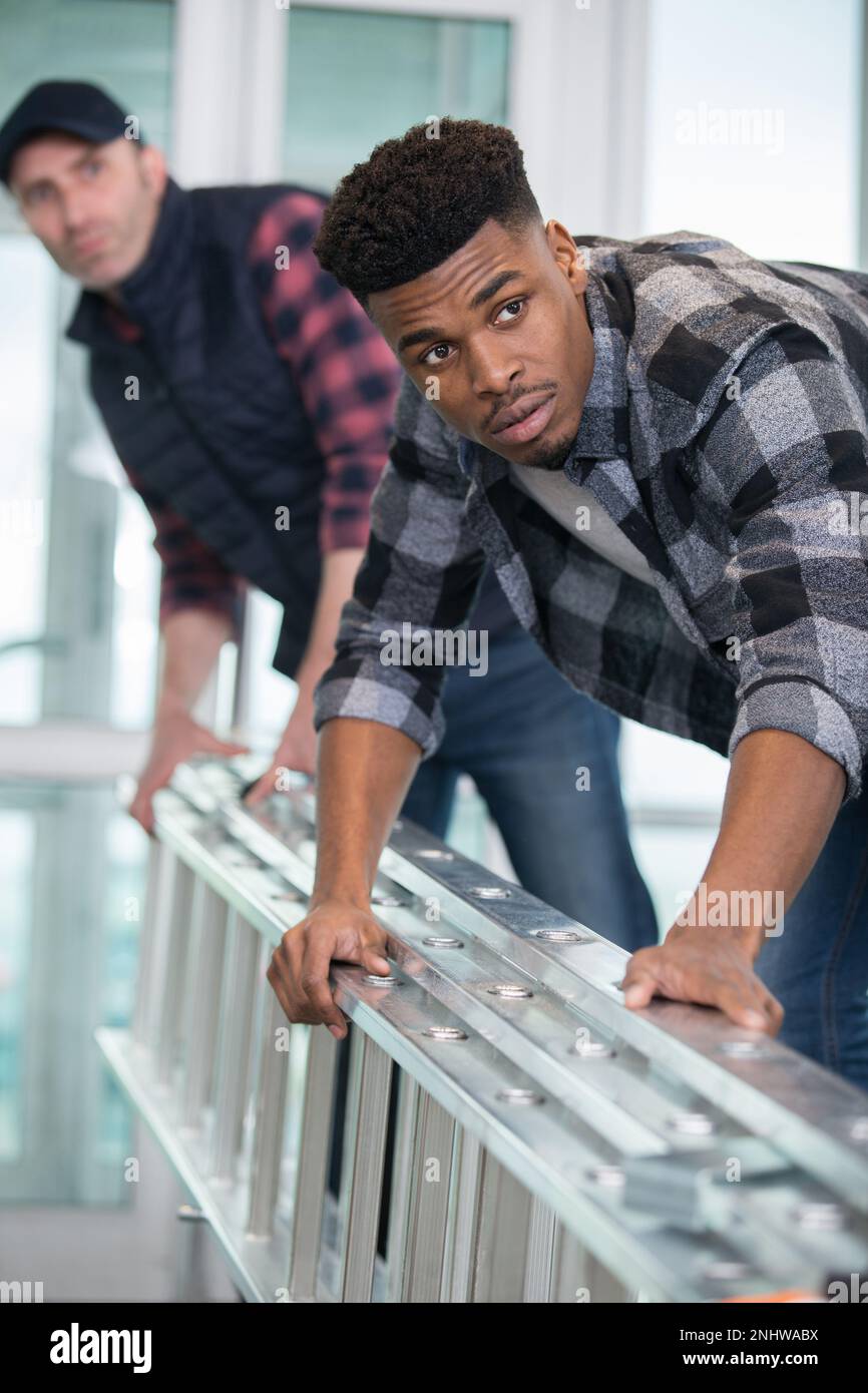 workers holding ladder at construction site Stock Photo - Alamy