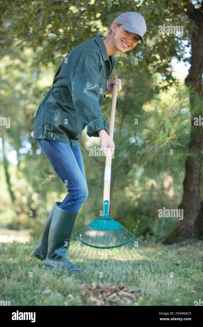 picture from a young and beautiful gardener with leaf rake Stock Photo ...