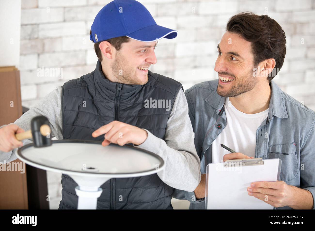 2 happy men in fixing a chair Stock Photo - Alamy