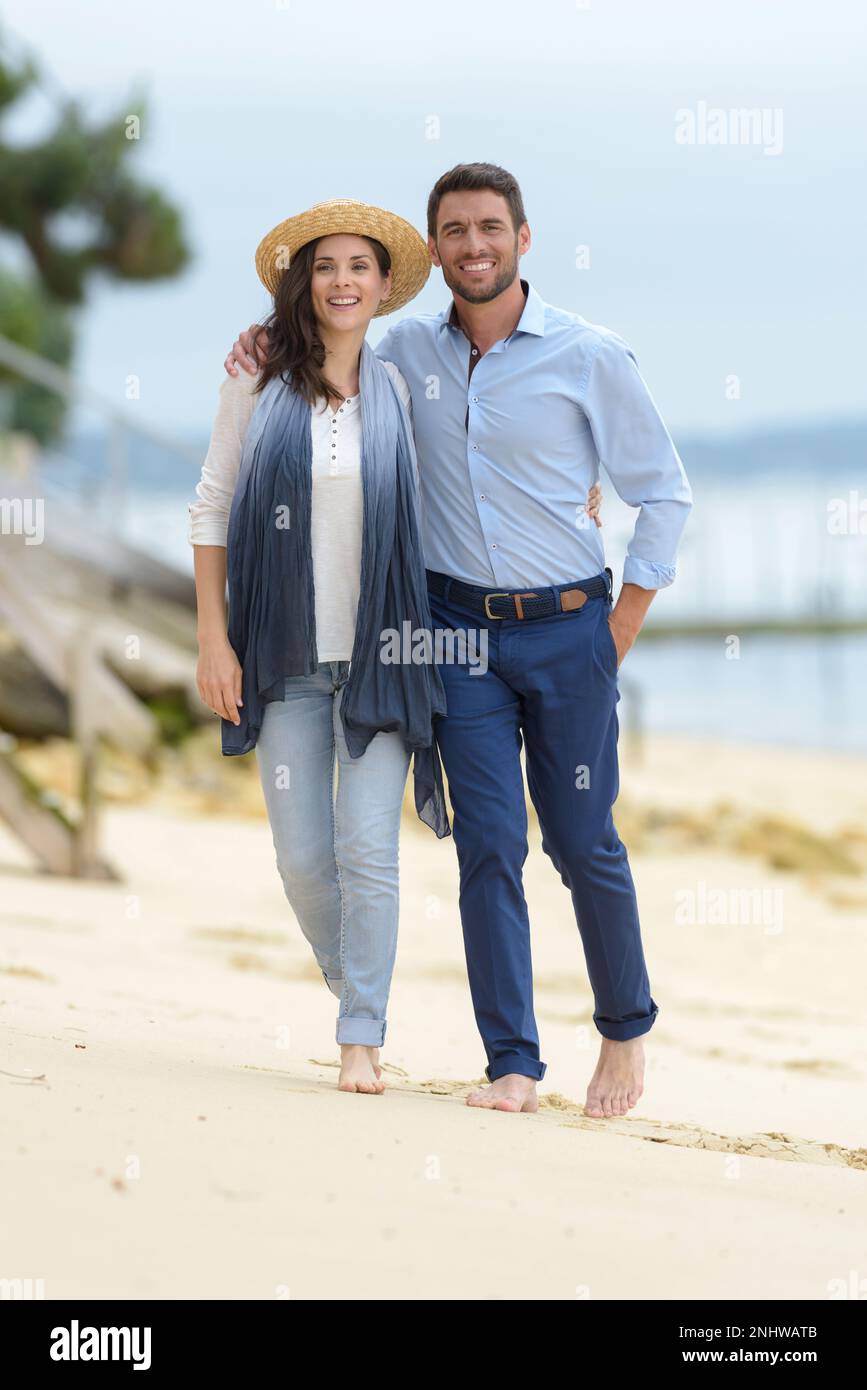 couple walking side by side on beach holding hands Stock Photo - Alamy