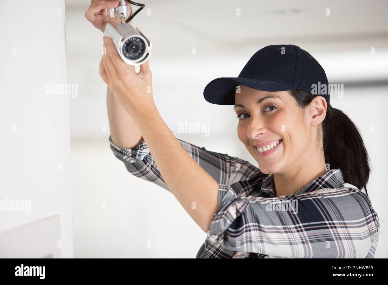 female worker installing cctv camera Stock Photo - Alamy