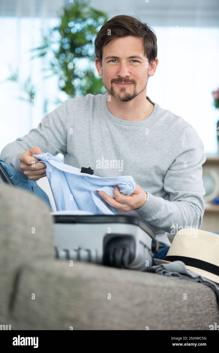 man closes suitcase with to much clothes Stock Photo - Alamy
