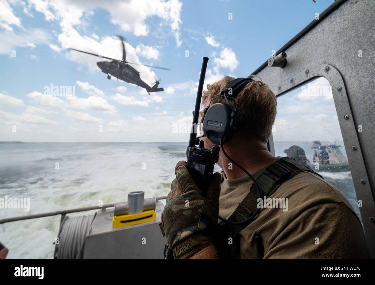 An FBI Hostage Rescue Team member communicates with a H-60M Black Hawk ...