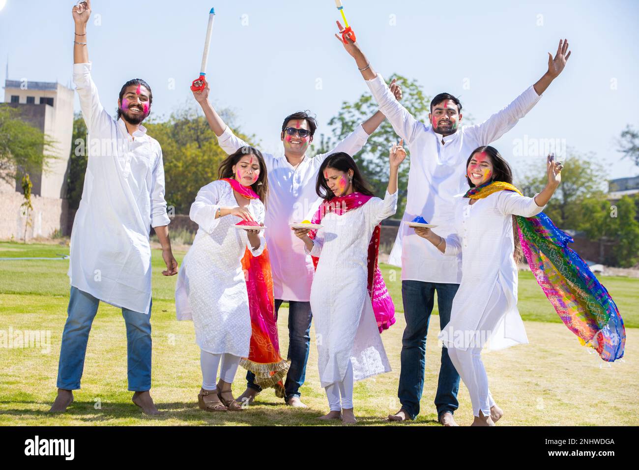 Group of cheerful young Indian family celebrating holi festival at park ...