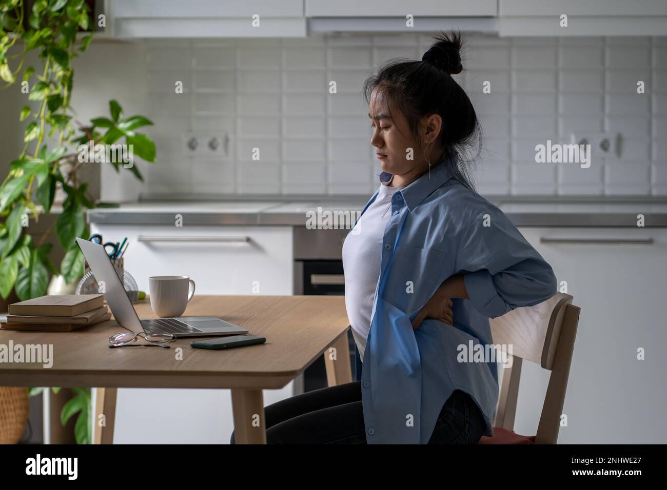 Tired Asian young female feeling fatigued from laptop work in incorrect ...