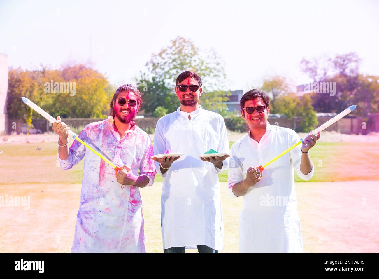 Portrait of happy young Indian men wearing white kurta holding plate ...