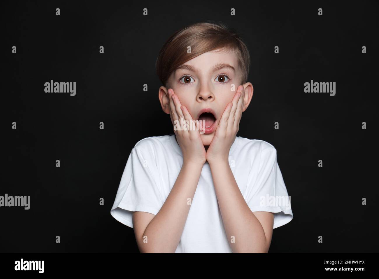 Little boy feeling fear on black background Stock Photo - Alamy