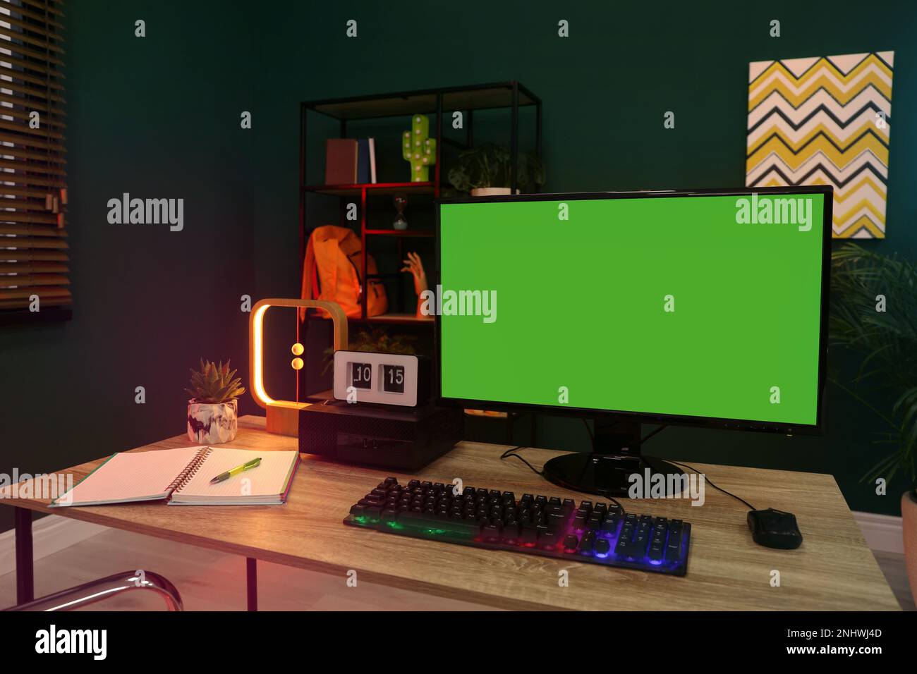 Modern computer and RGB keyboard on wooden table indoors. Mockup green ...