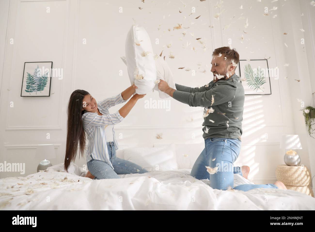 Happy young couple having fun pillow fight in bedroom Stock Photo - Alamy
