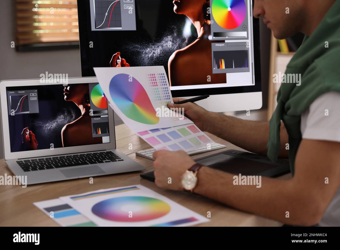 Professional retoucher with color palettes at workplace indoors ...