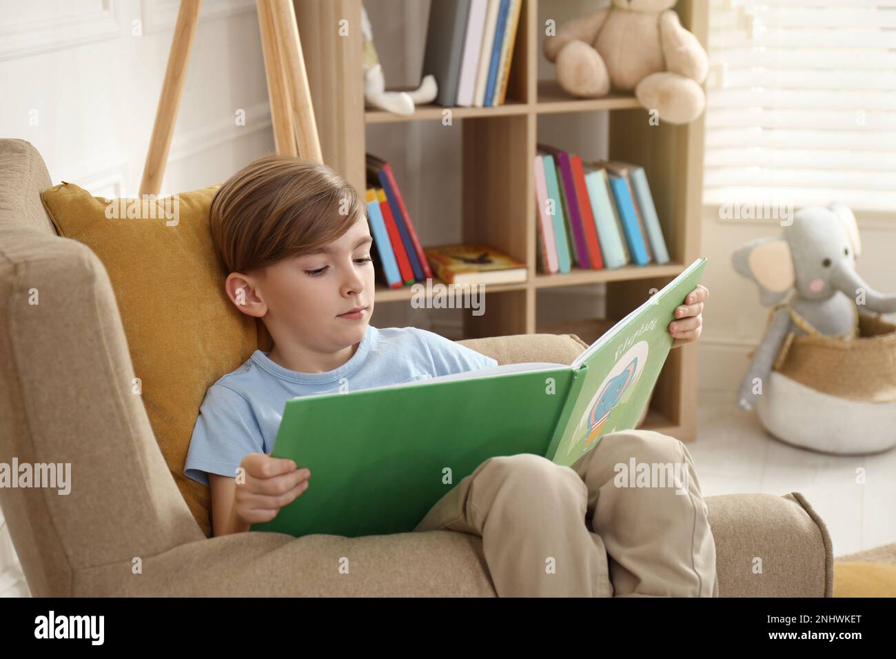 Little boy reading in armchair hi-res stock photography and images - Alamy