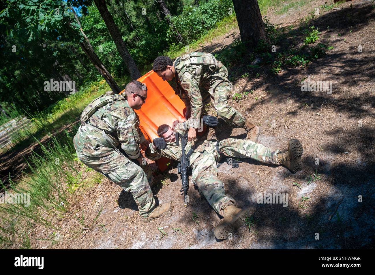 U.S. Air Force Airmen buddy carry a simulated casualty during ...