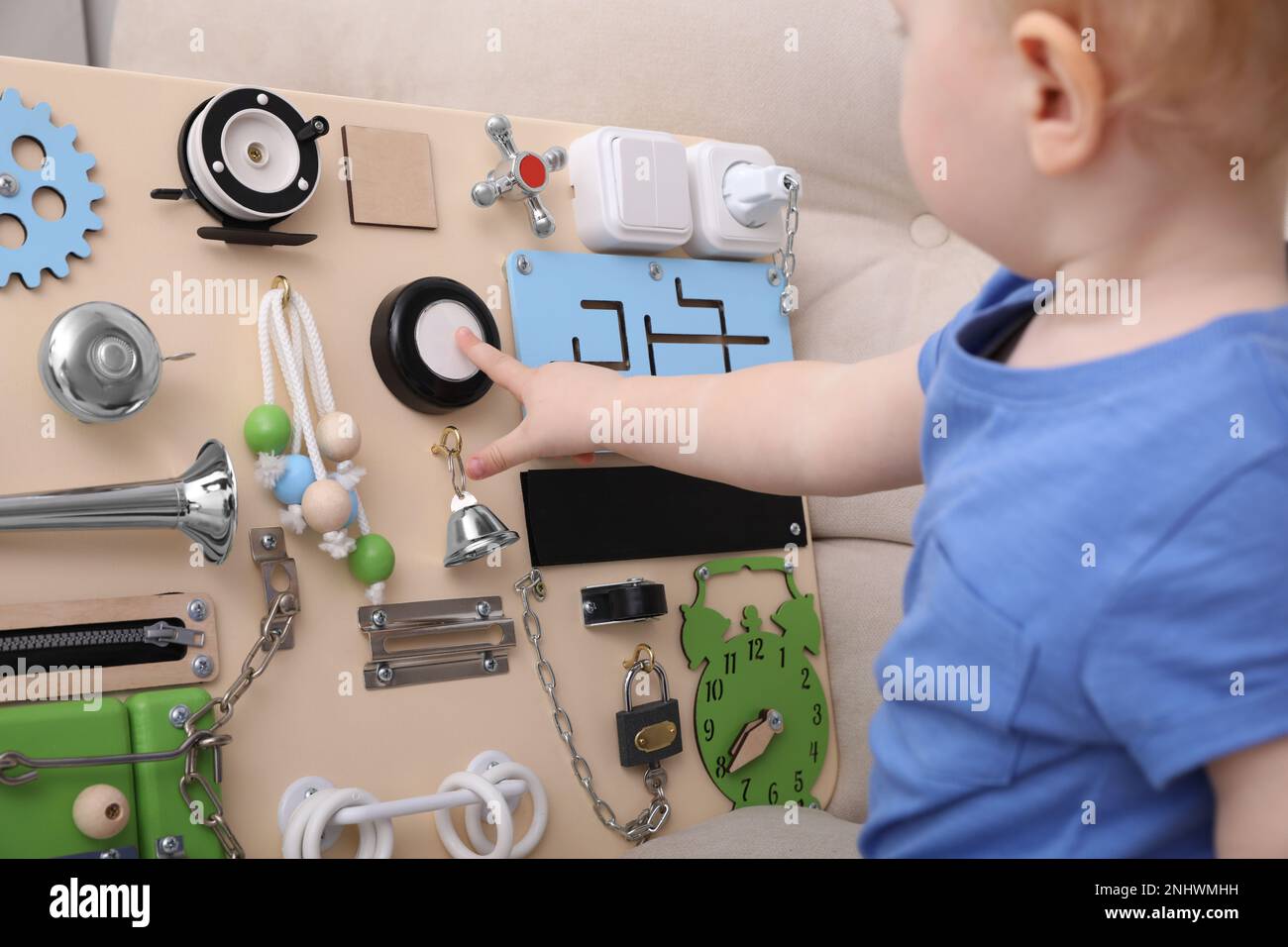 Cute little boy playing with busy board on sofa, closeup Stock Photo ...