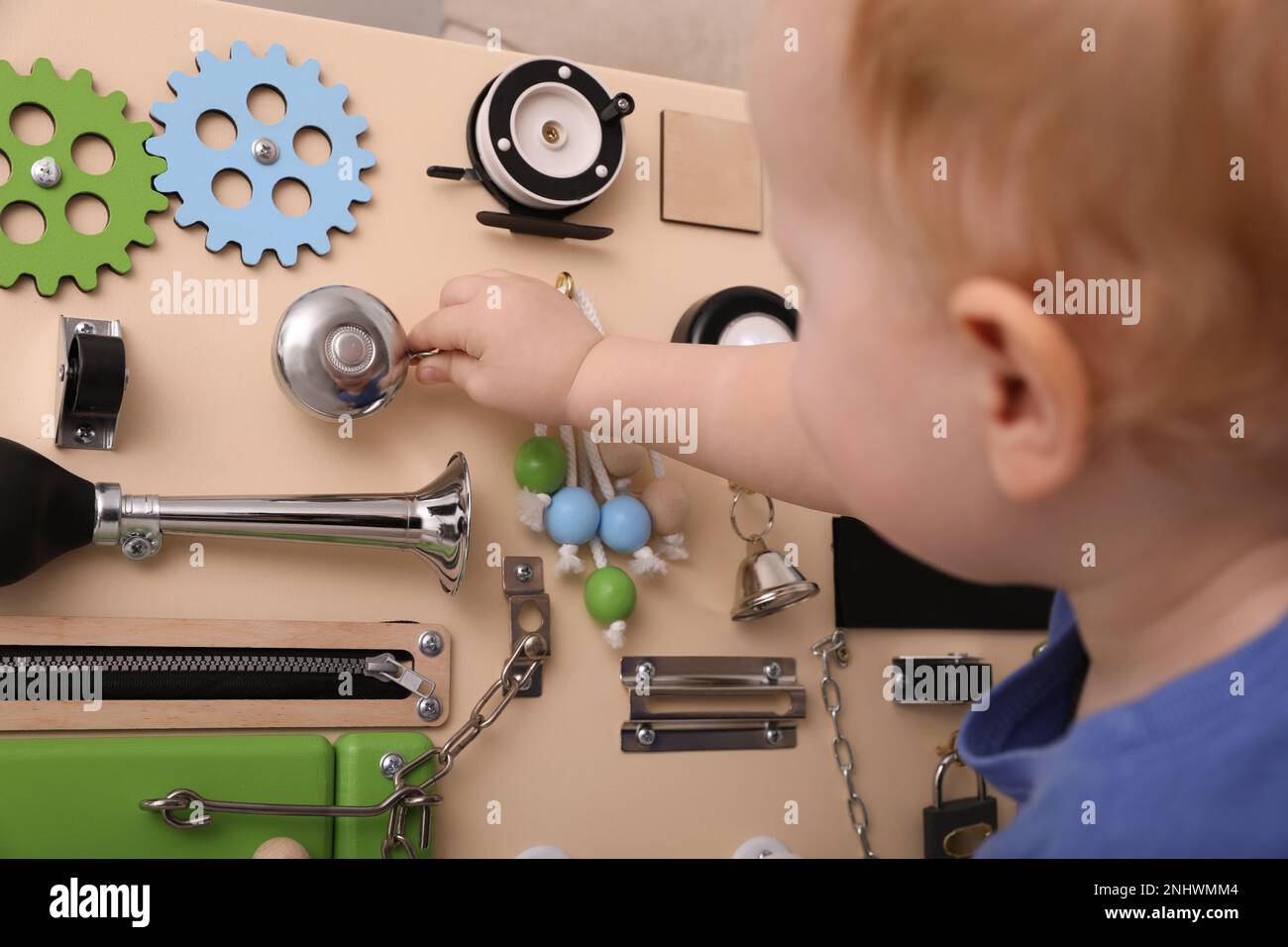Cute little boy playing with busy board, focus on hand Stock Photo - Alamy