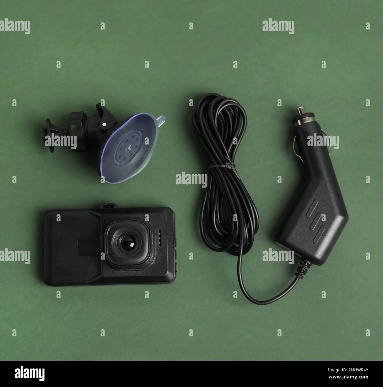 Modern car dashboard camera, suction mount and charger on dark green ...