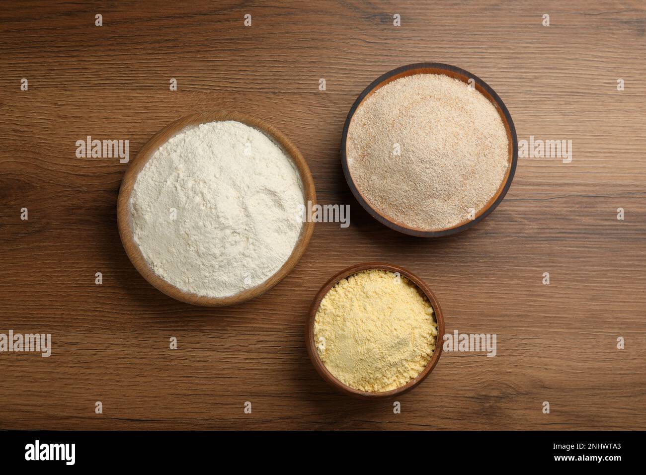 Different types of flours in bowls on wooden table, flat lay Stock ...