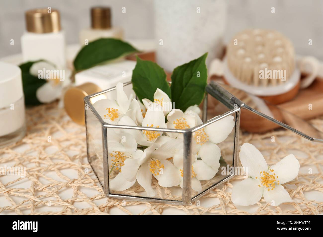 Glass box with beautiful jasmine flowers and skin care products on ...