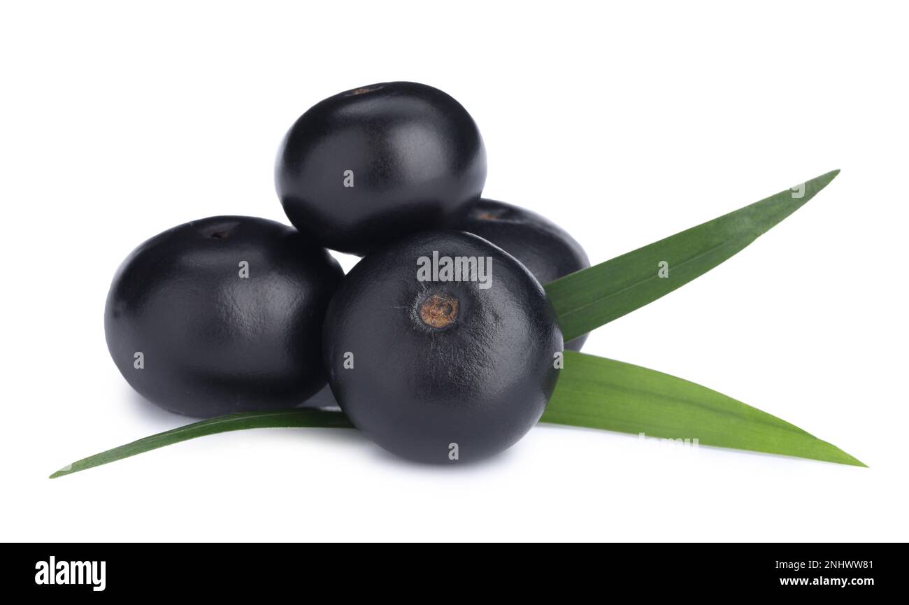 Pile of fresh ripe acai berries and green leaves on white background ...