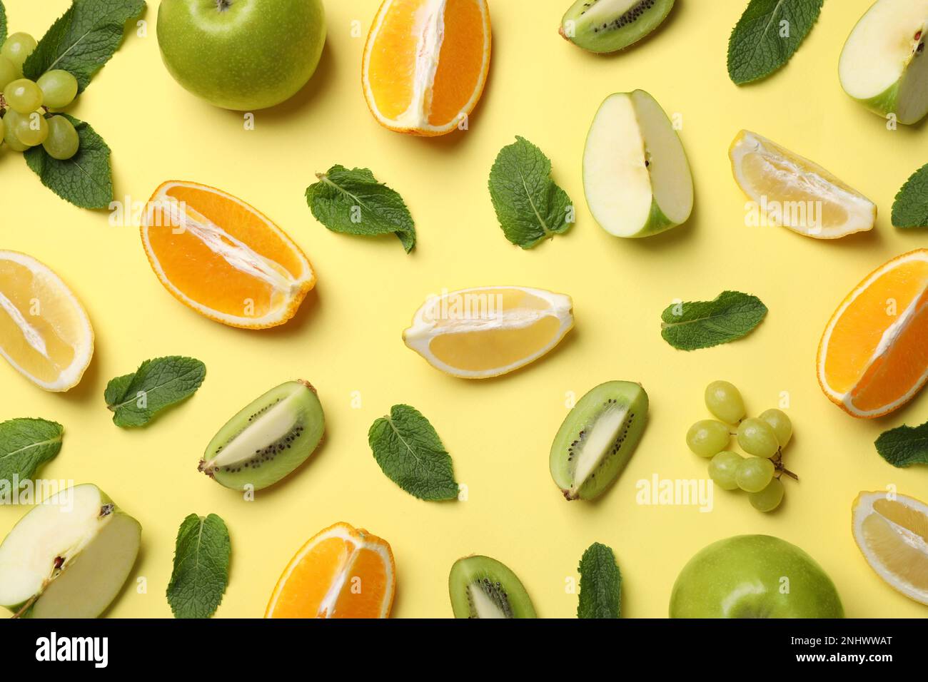 Different fresh ripe fruits and mint on yellow background, flat lay ...