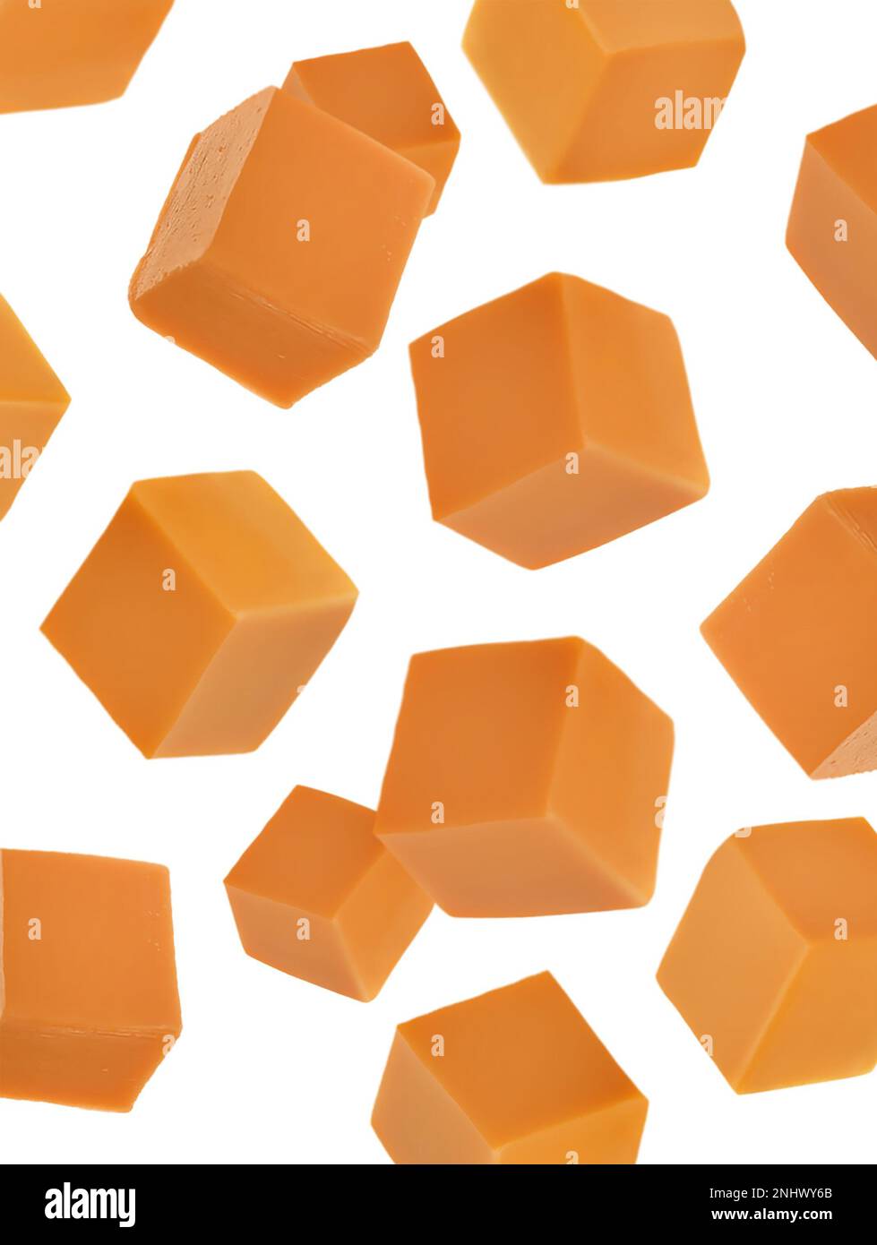 Delicious caramel cubes flying on white background Stock Photo - Alamy