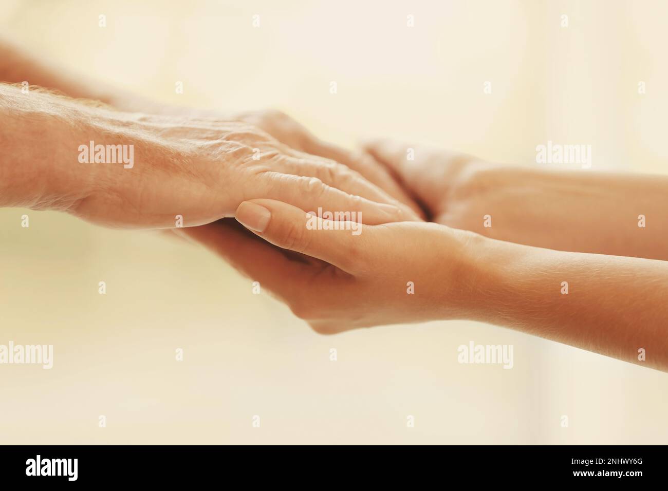 Helping hands on blurred background, closeup. Elderly care concept ...