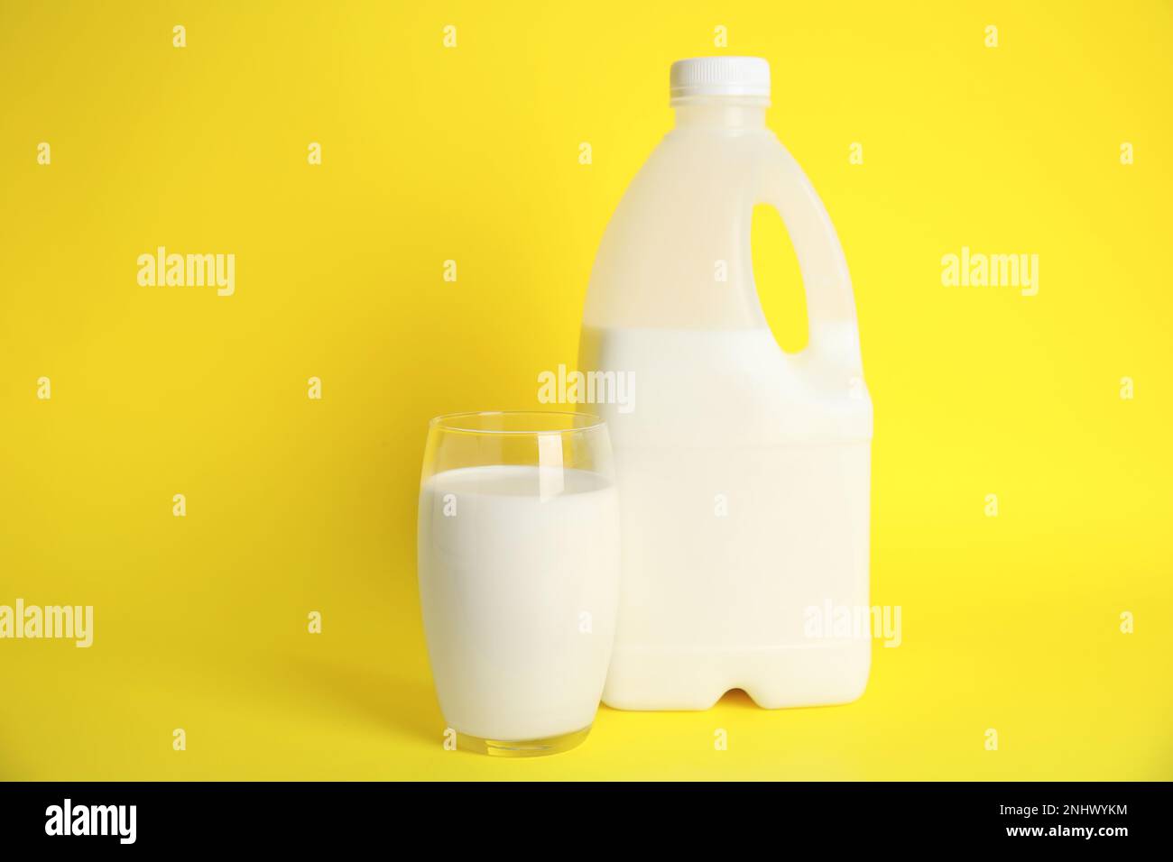 Gallon bottle and glass of milk on yellow background Stock Photo - Alamy