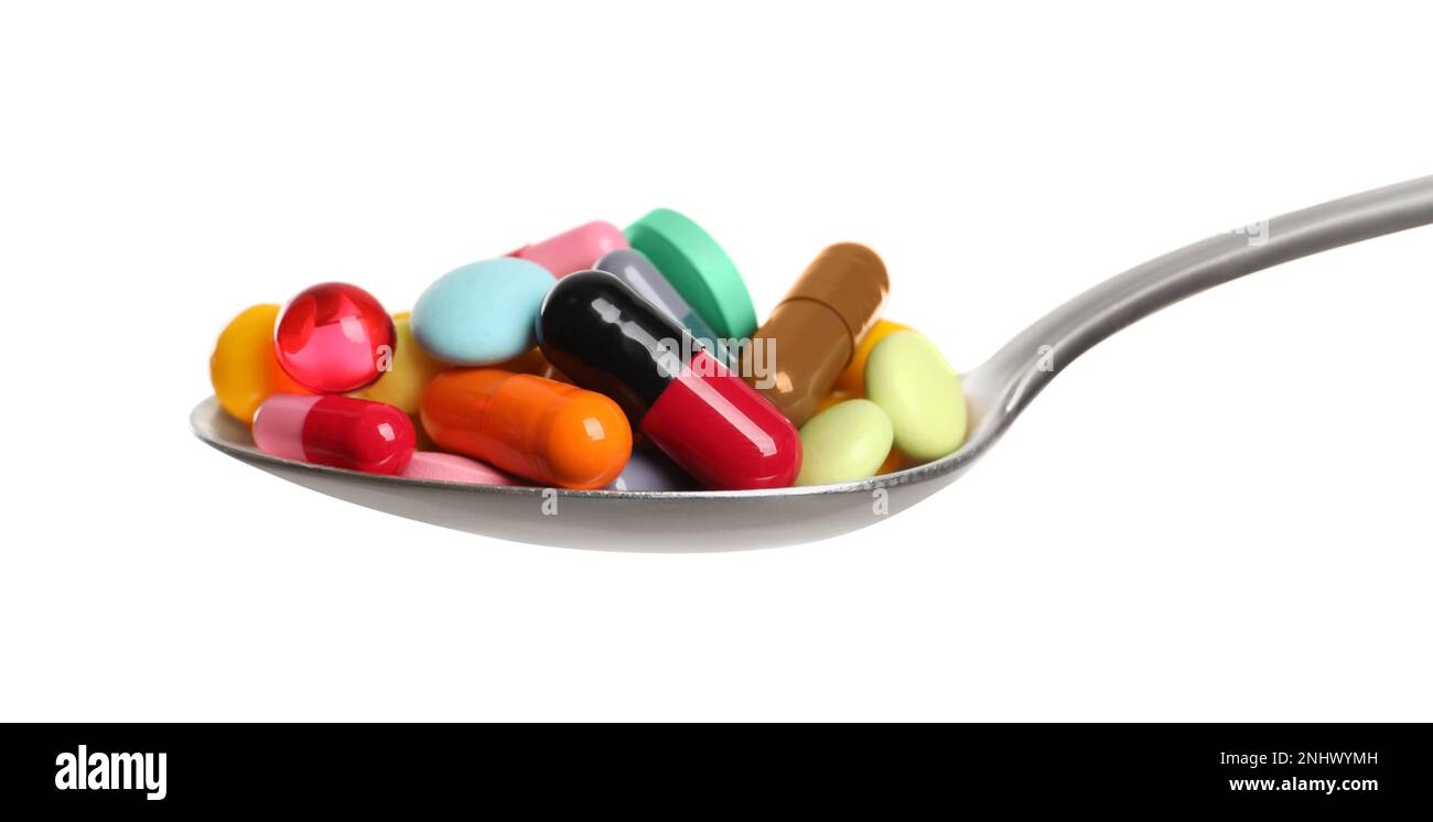 Spoon with different colorful pills on white background Stock Photo - Alamy