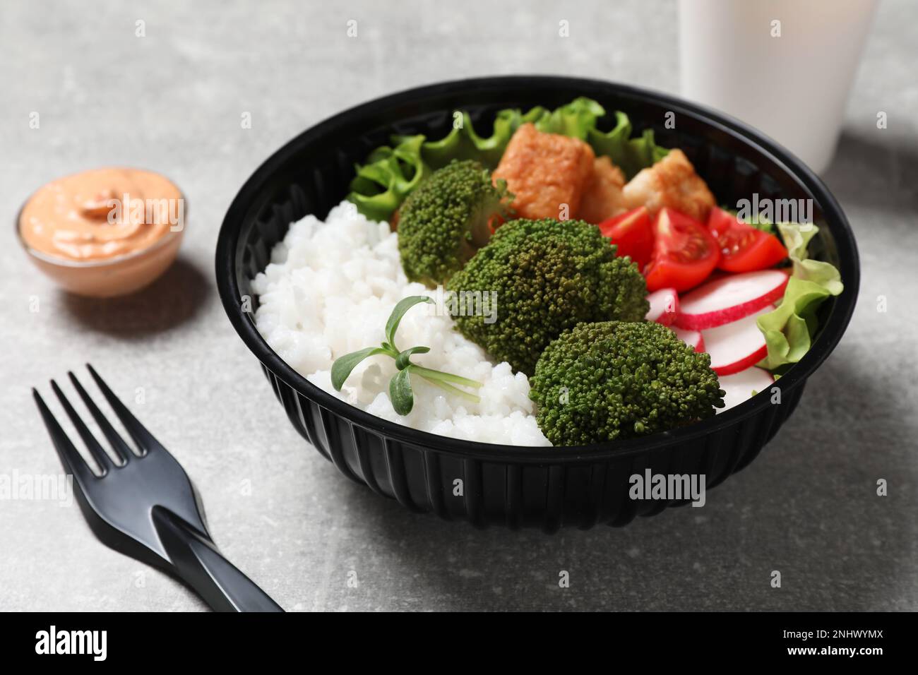 Healthy takeaway meal in plastic bowl on light grey table Stock Photo ...