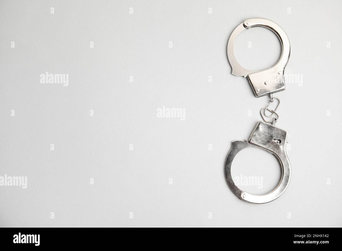 Classic chain handcuffs on white background, top view. Space for text ...