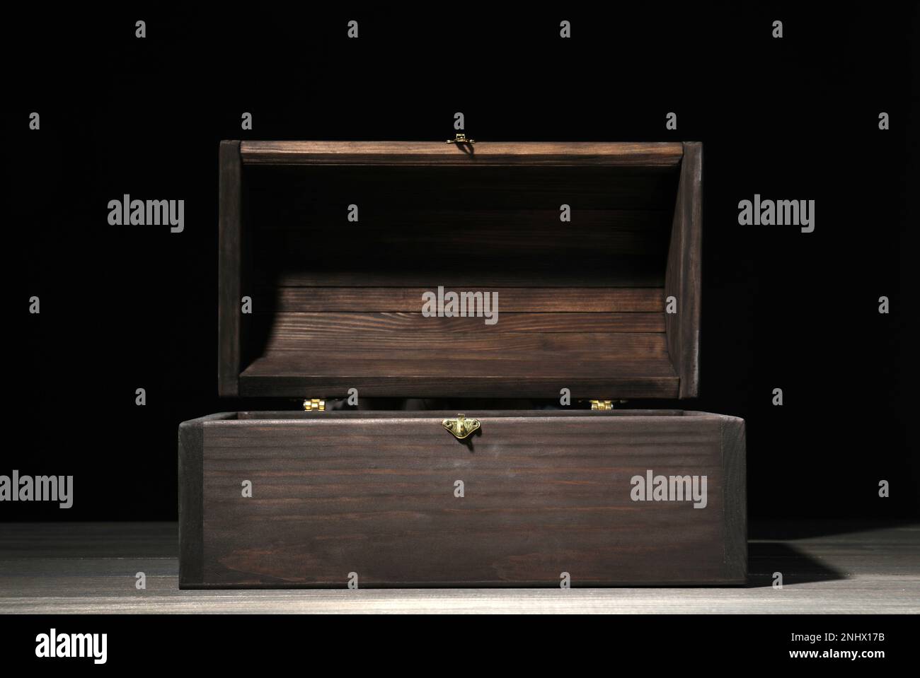 Empty treasure chest on wooden table against black background Stock ...